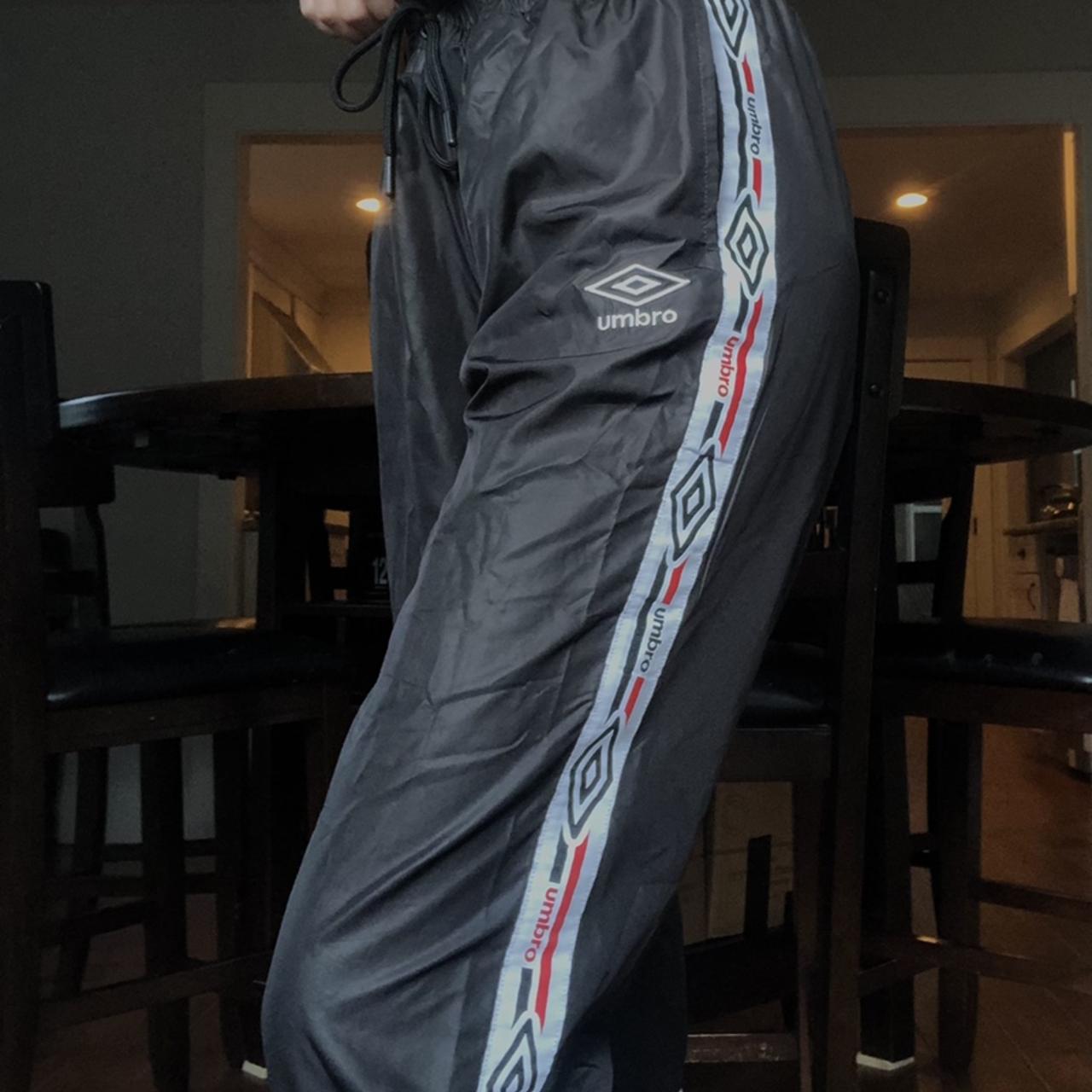 Black Umbro track pants with white lines on both... - Depop