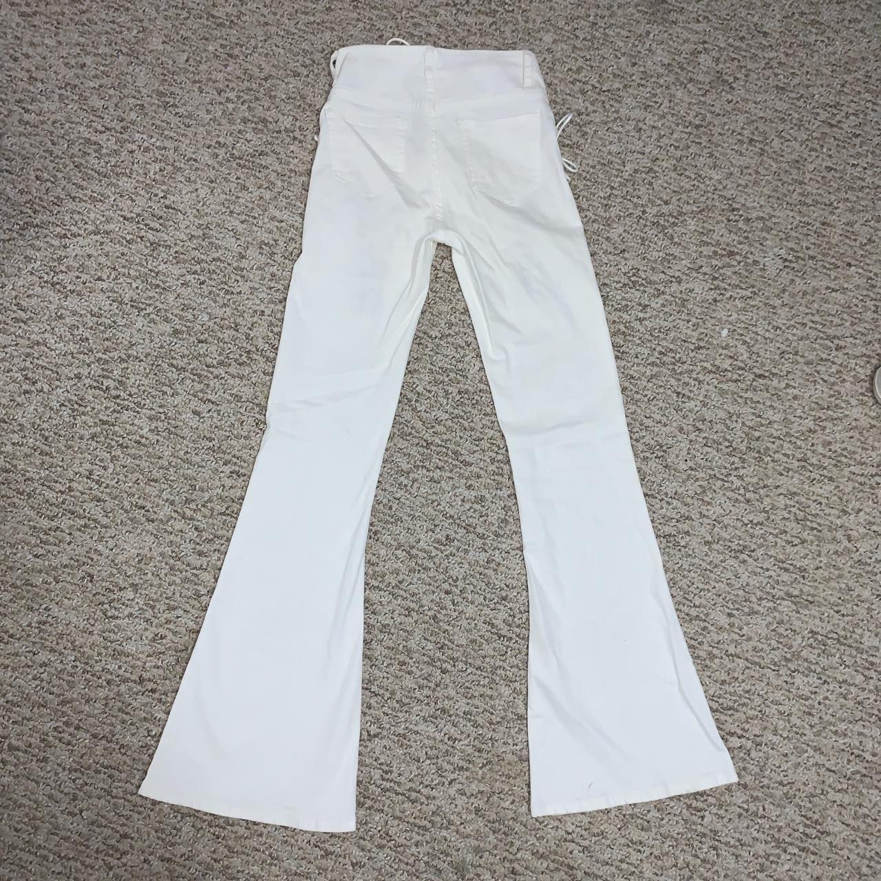 White flared jeans with lace up details on... - Depop