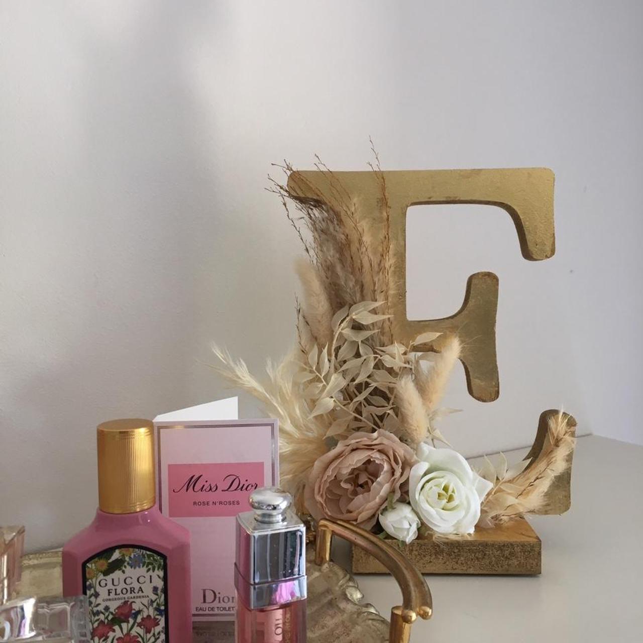 The gold events, initial E covered in faux flowers... - Depop