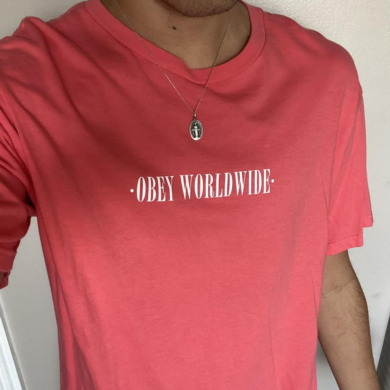 Salmon pink OBEY WORLDWIDE logo white text short... - Depop