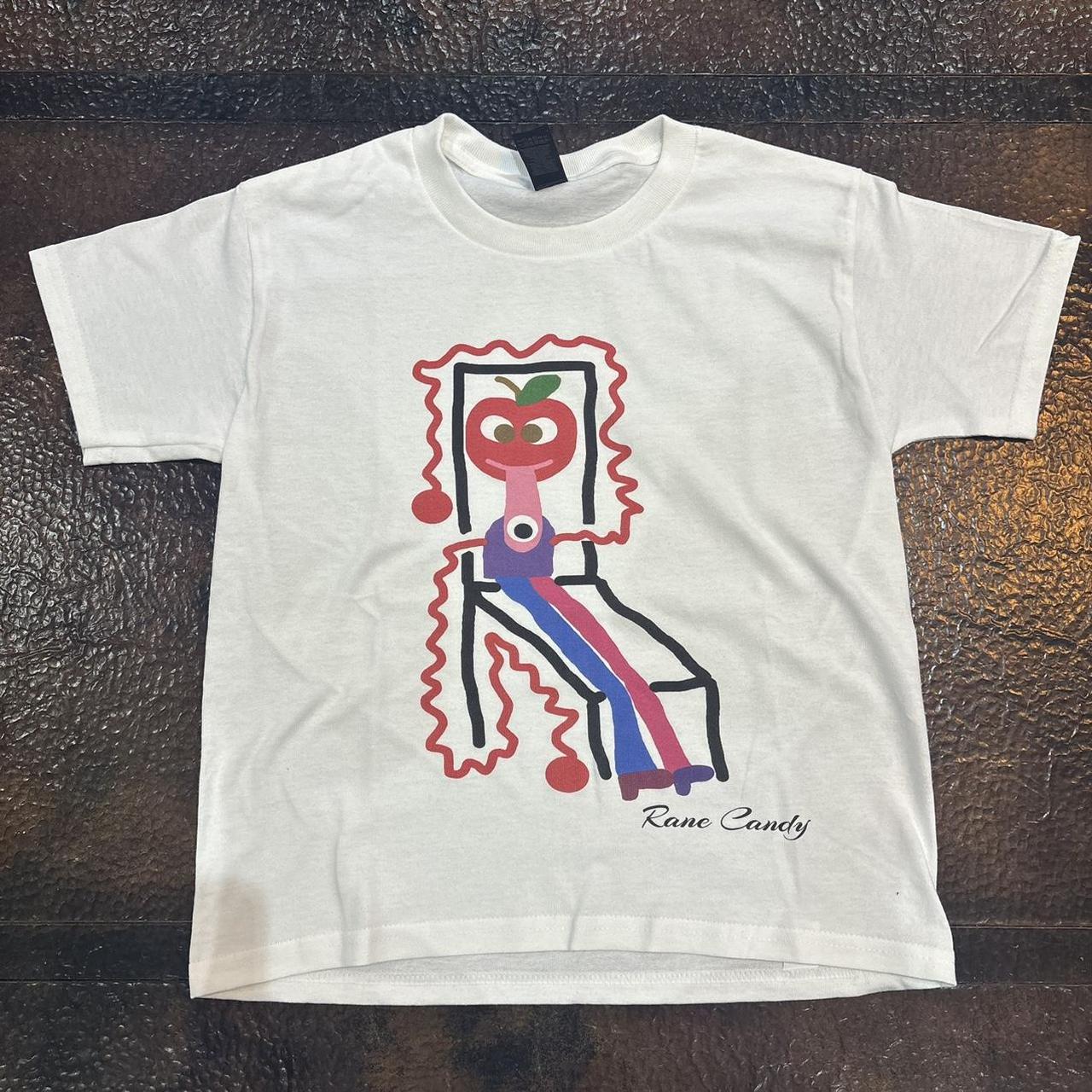 Apple with long squiggly arms sitting on chair... | Depop