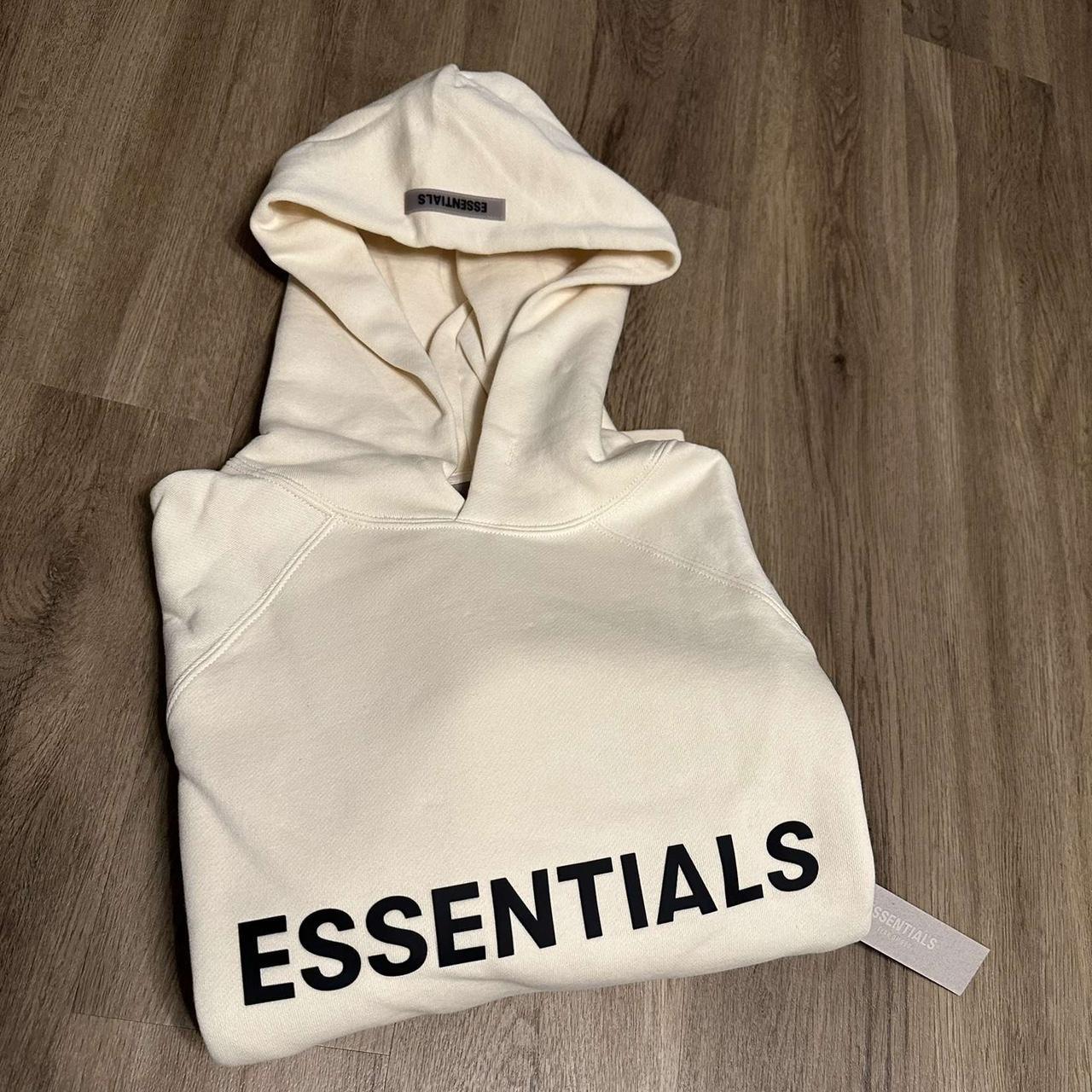 Essentials hoodie fear of god in cream with black... - Depop