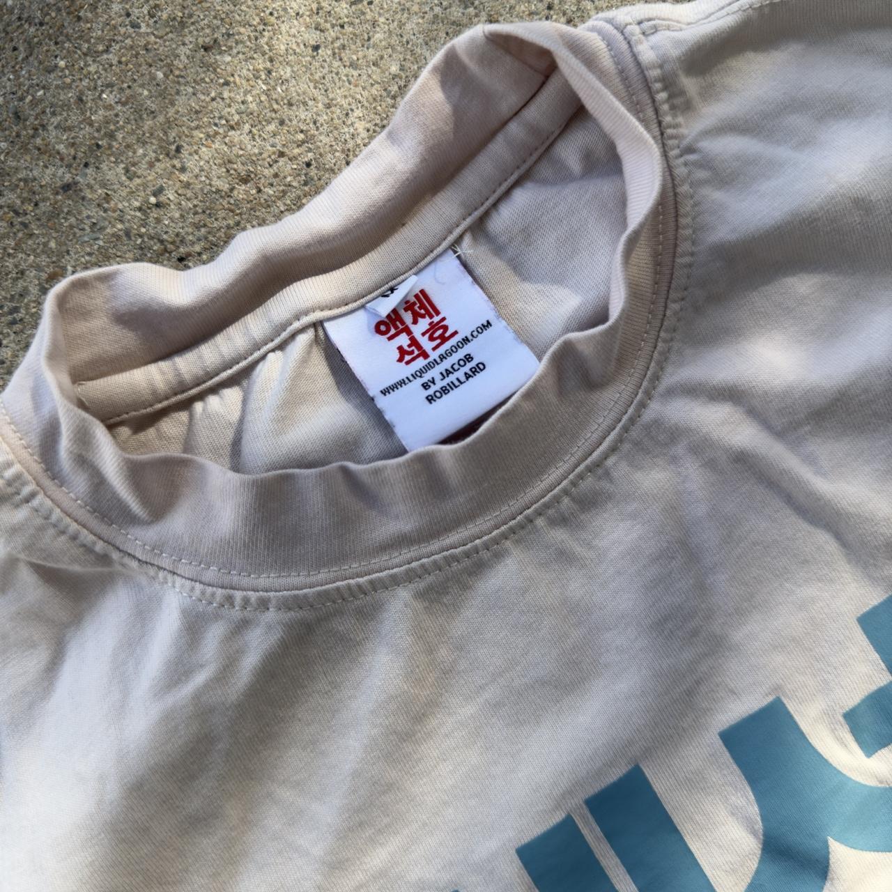 Liquid Lagoon Goon City Tee. Cream with blue print. - Depop