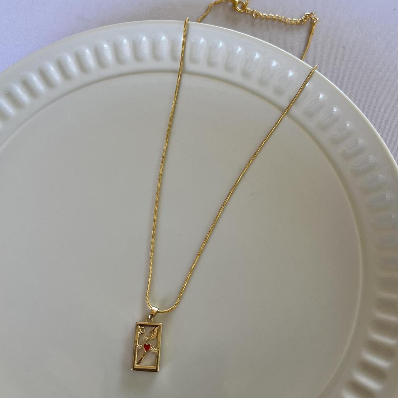 gold rectangle pendant with white, gold, and red... - Depop