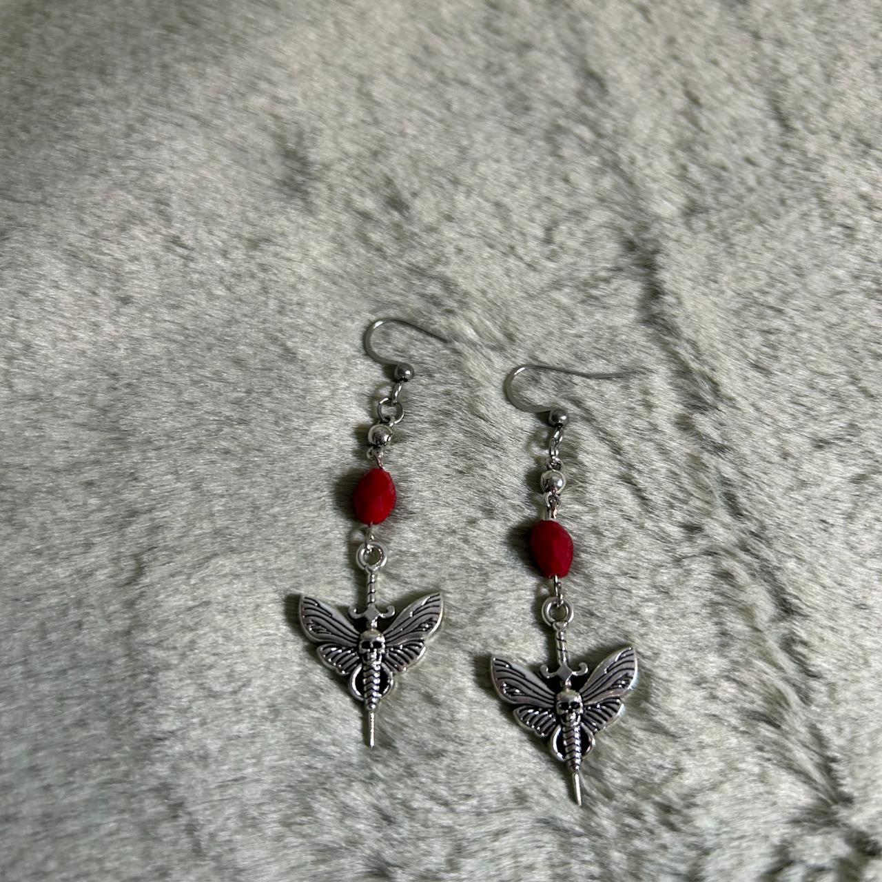 silver moth on sword charm with red bead earrings... - Depop