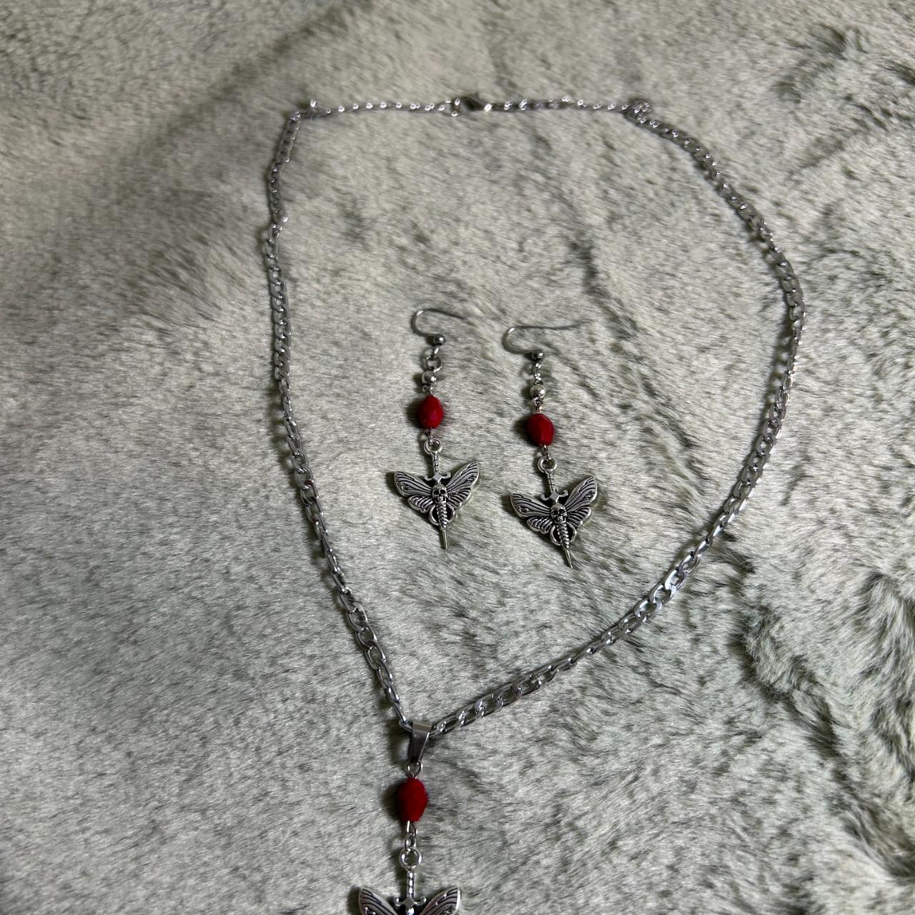 silver moth on sword charm with red bead earrings... - Depop