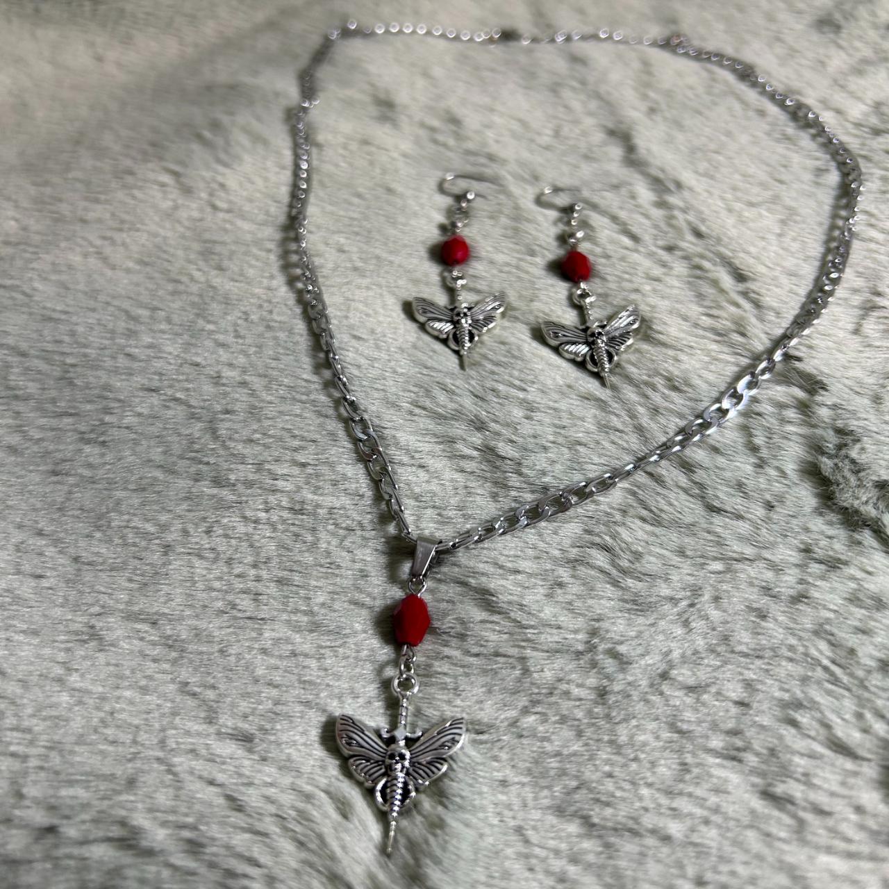 silver moth on sword charm with red bead earrings... - Depop