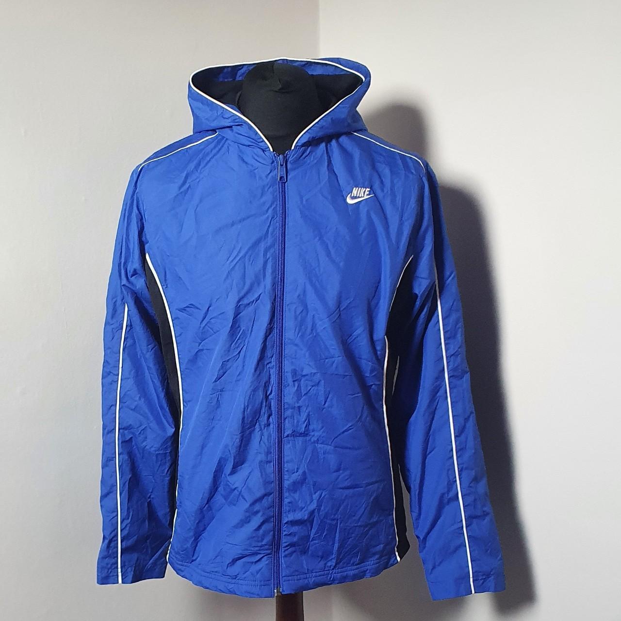 A medium blue Nike zip-up hooded jacket with white... - Depop