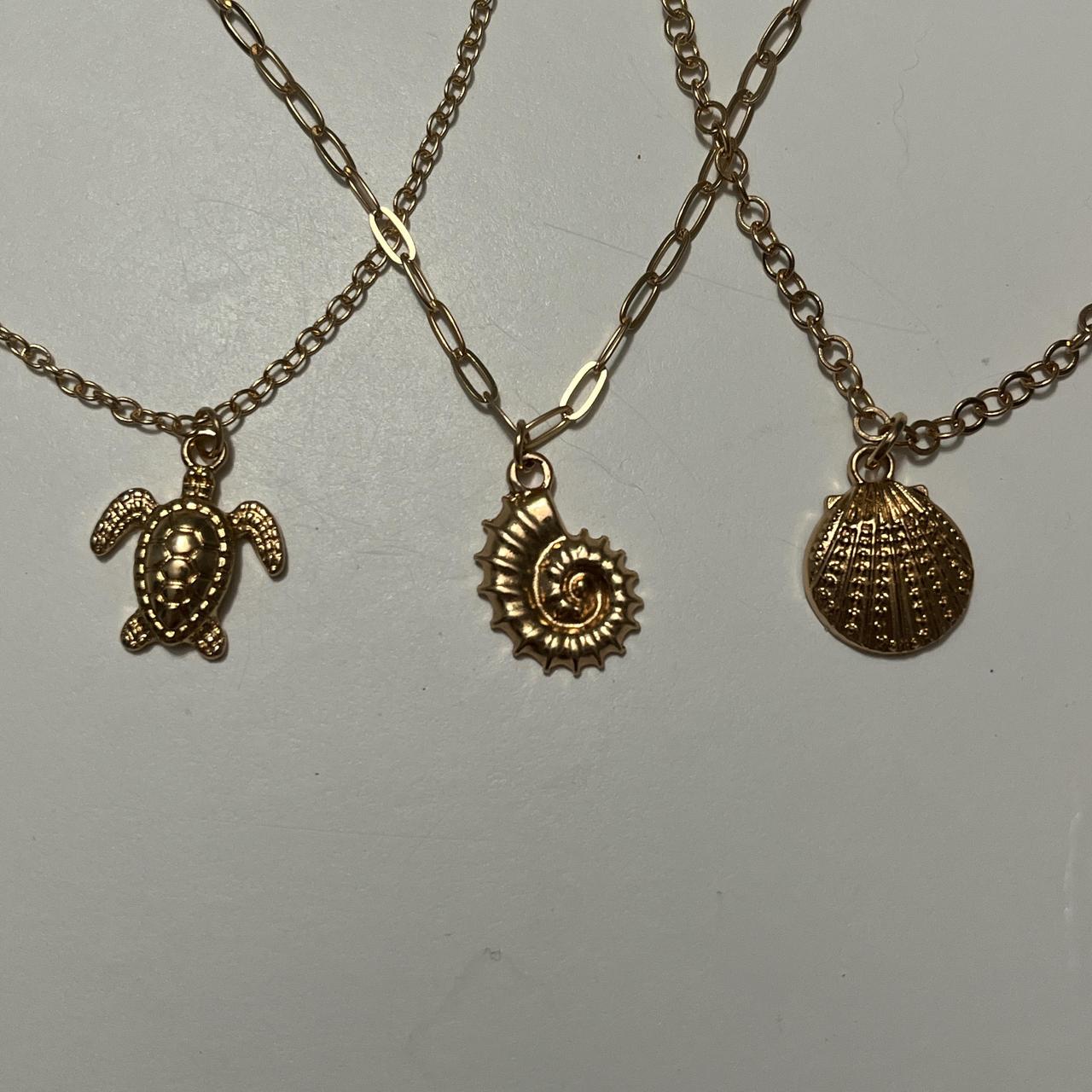 Gold necklace set featuring a turtle, spiral shell,... | Depop