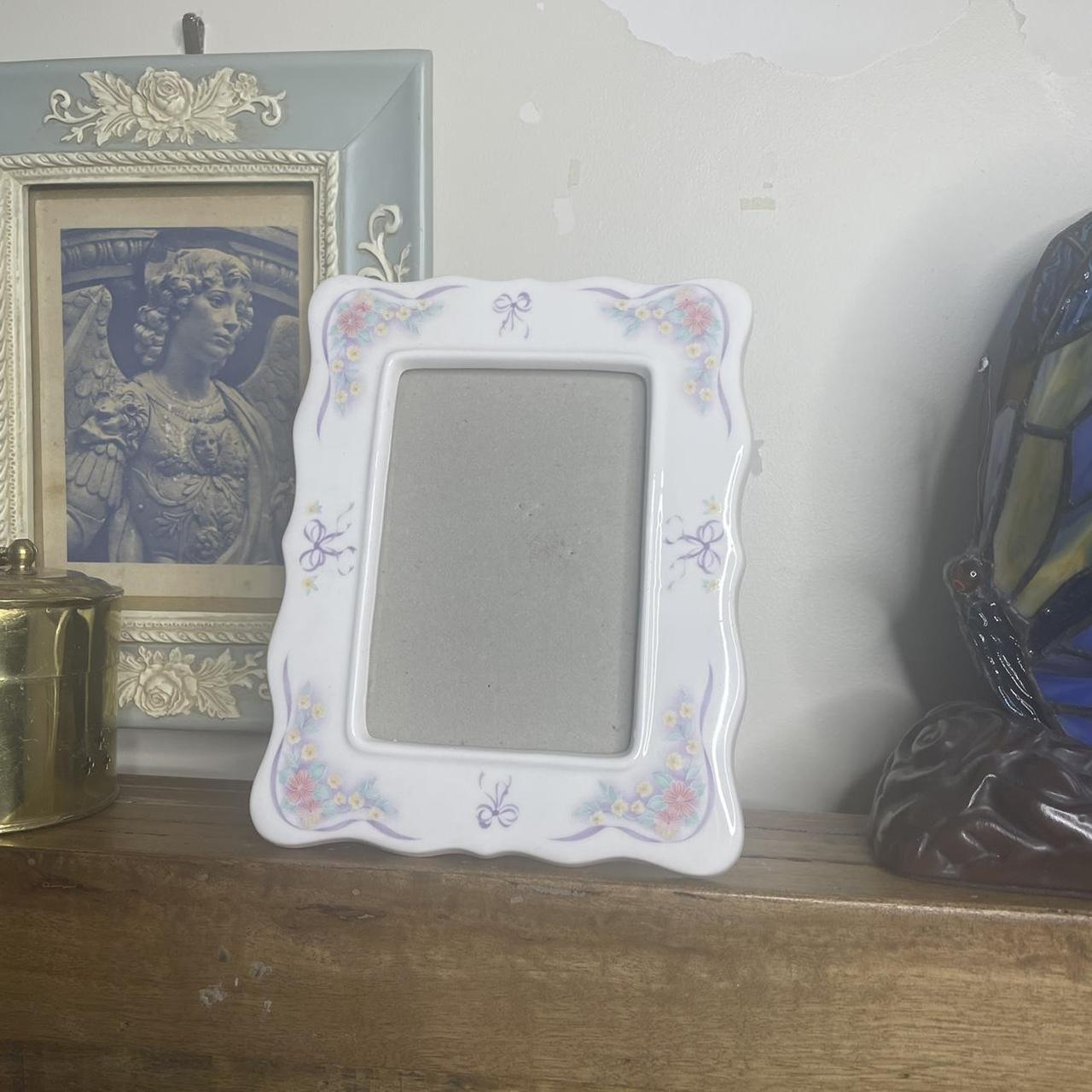 Porcelain frame with a floral and ribbon border... - Depop
