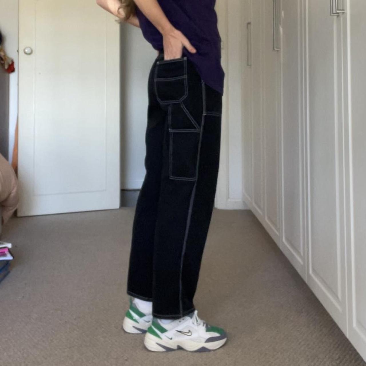 black lioness-style pants with white stitching... - Depop