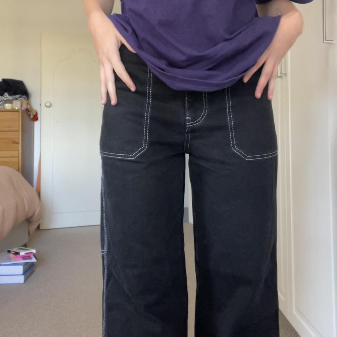 black lioness-style pants with white stitching... - Depop