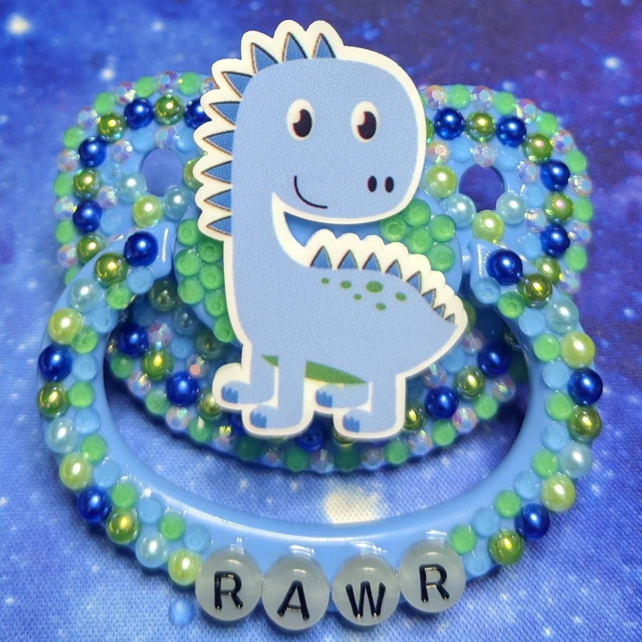 Blue adult pacifier with dinosaur centerpiece,... - Depop