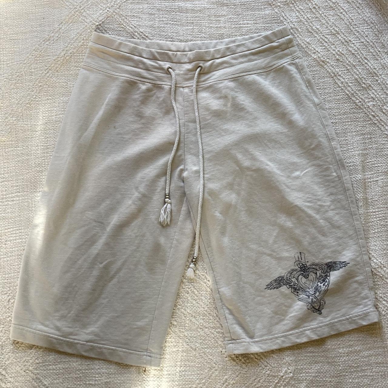 Y2K athleisure shorts with winged cyber graphic, has... - Depop