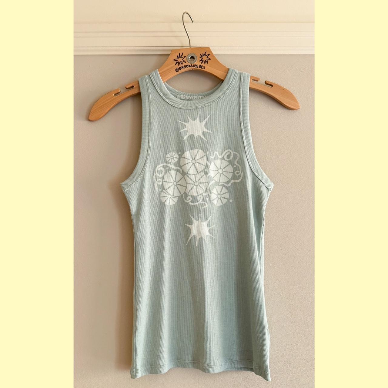 Pastel blue tank top. Block printed featuring... | Depop