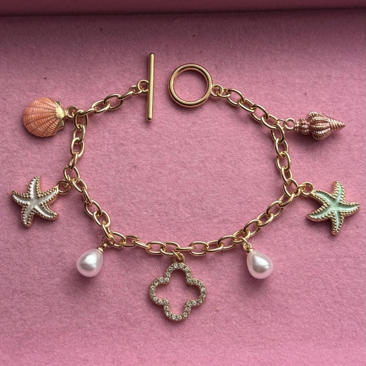 Gold tone bracelet with shells, starfish, and pearls... | Depop