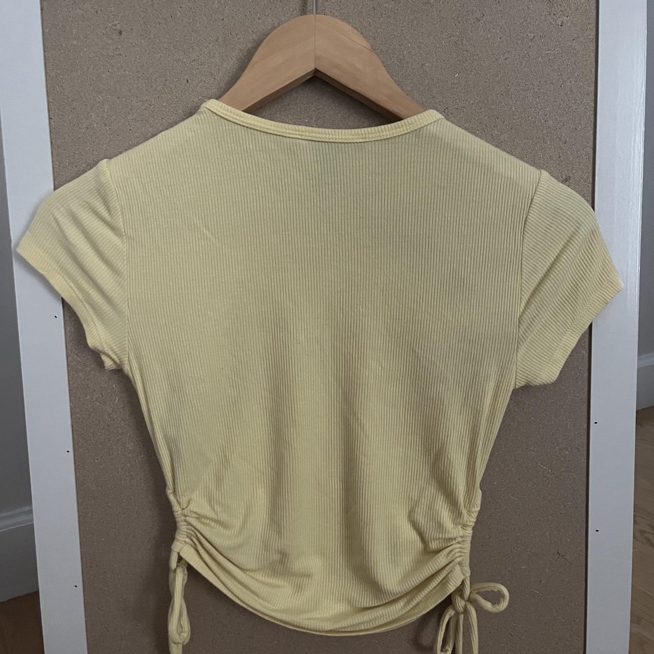 Baby yellow t-shirt with cinches on the sides of the... - Depop