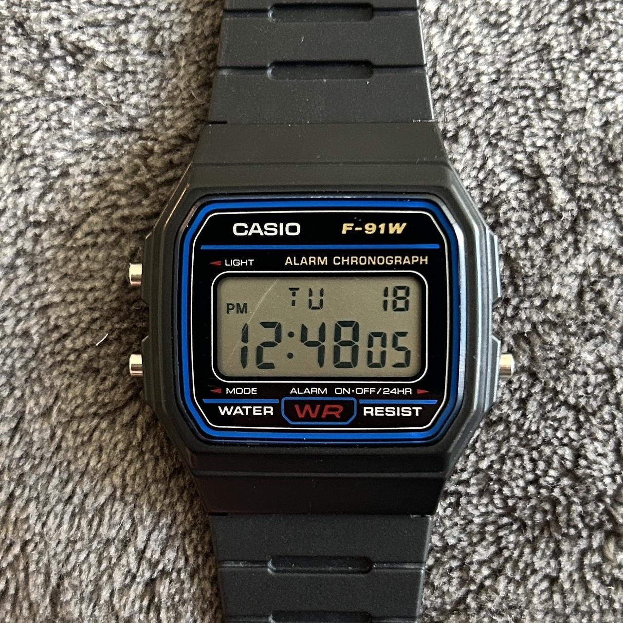 Black Casio F-91W digital watch with blue accents,... | Depop