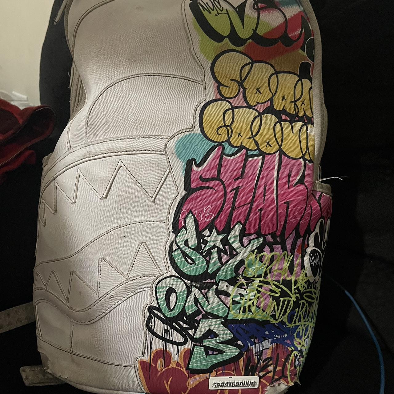 White and pink graffiti sprayground backpack with a... - Depop