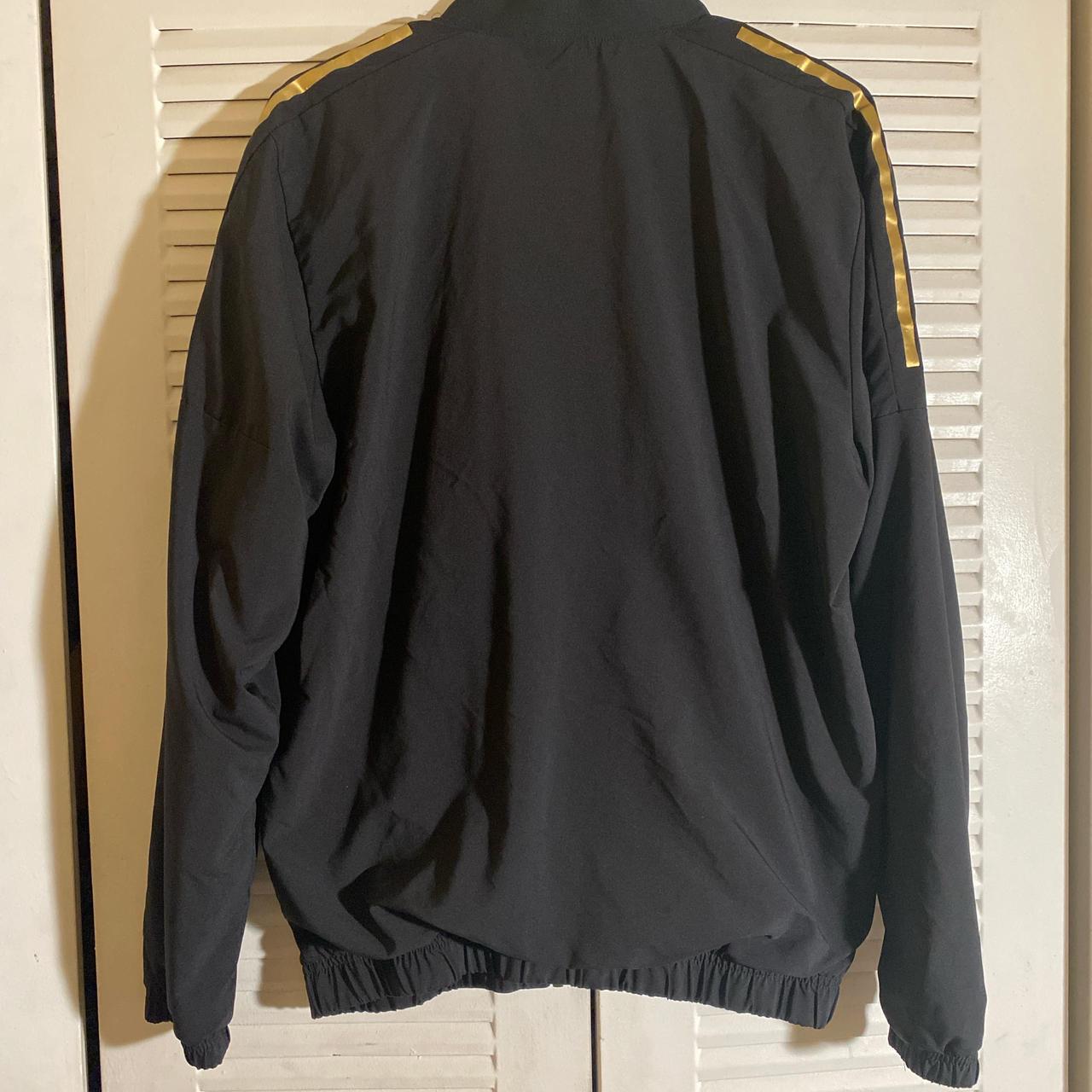small adidas jacket black with gold stripes, barely... - Depop