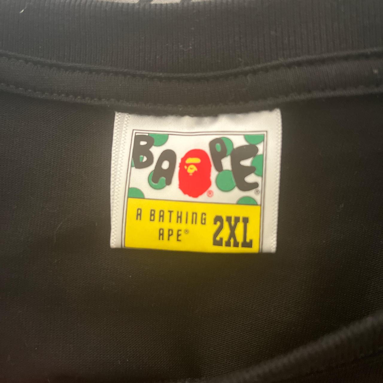 L black bape shirt with a big neck opening and tag... - Depop