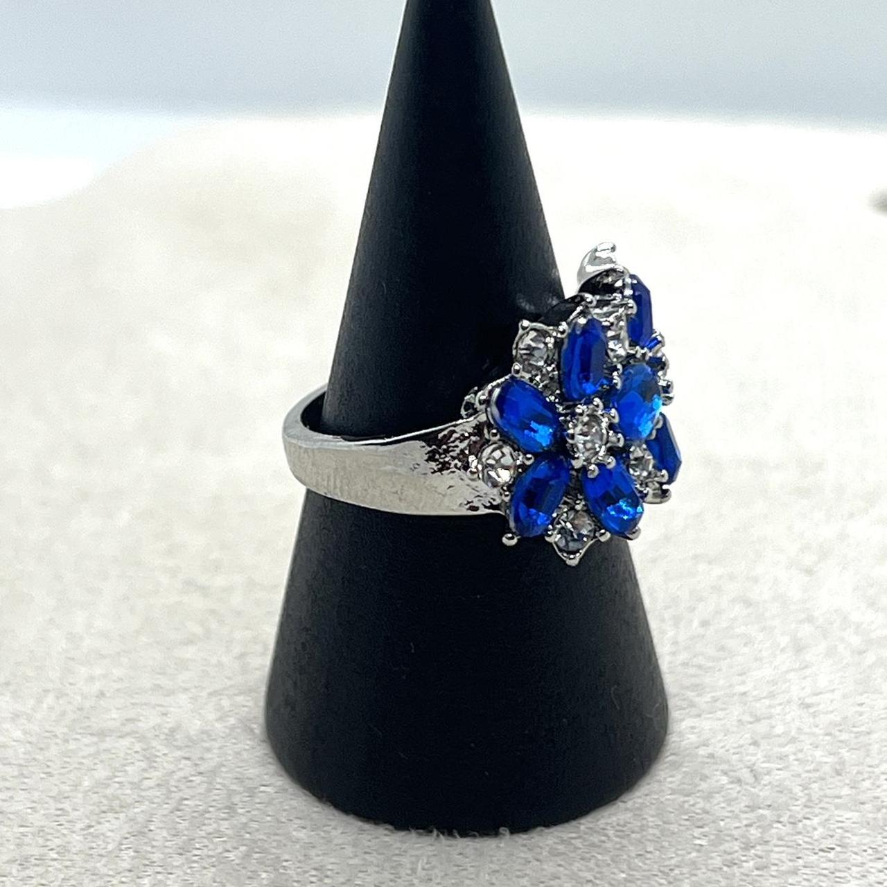 Silver colour ring with blue and white stones Size... - Depop