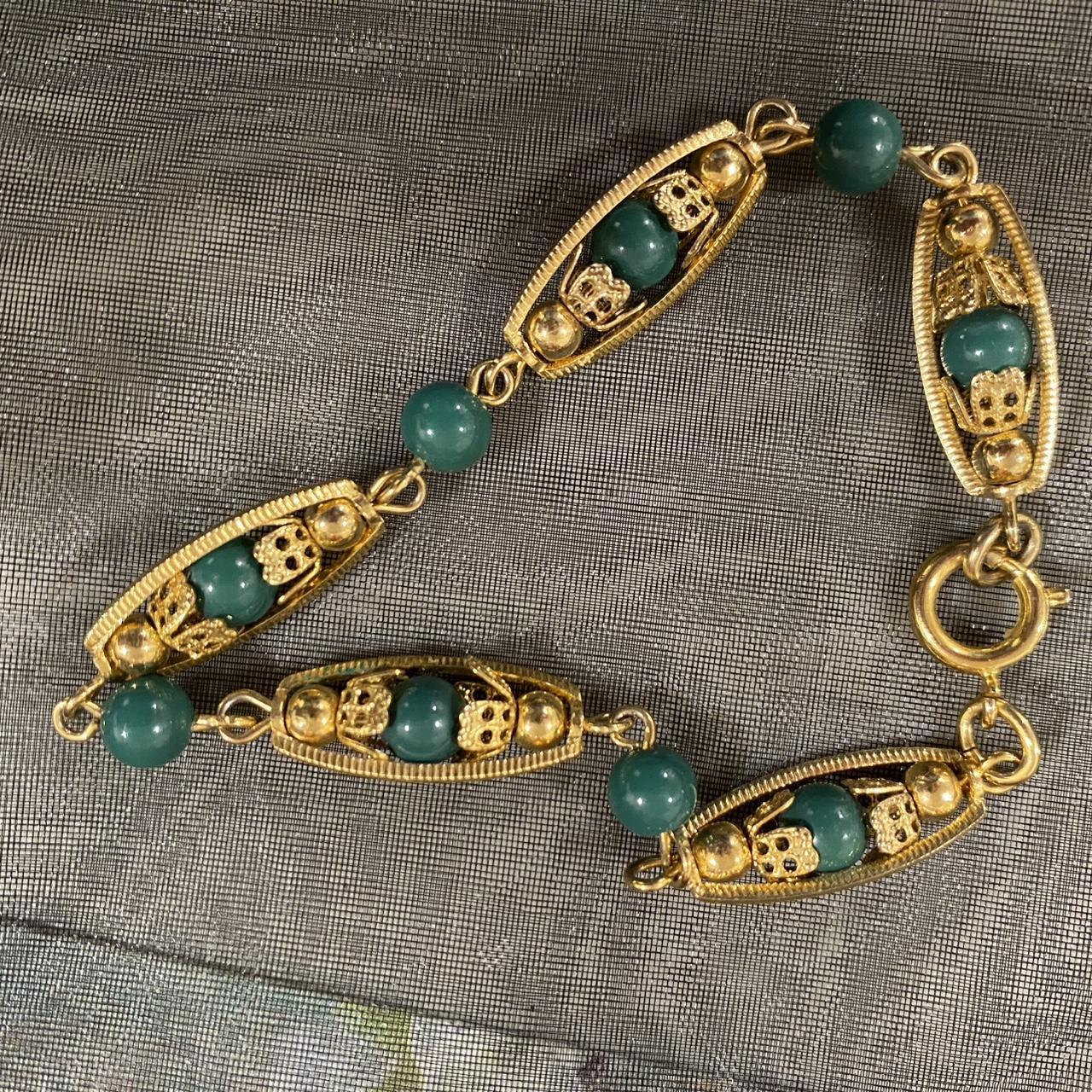 Gold tone bracelet with filigree braided green beads... - Depop