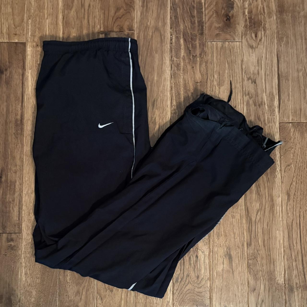 Black Nike tracksuit bottoms with white detailing a... | Depop
