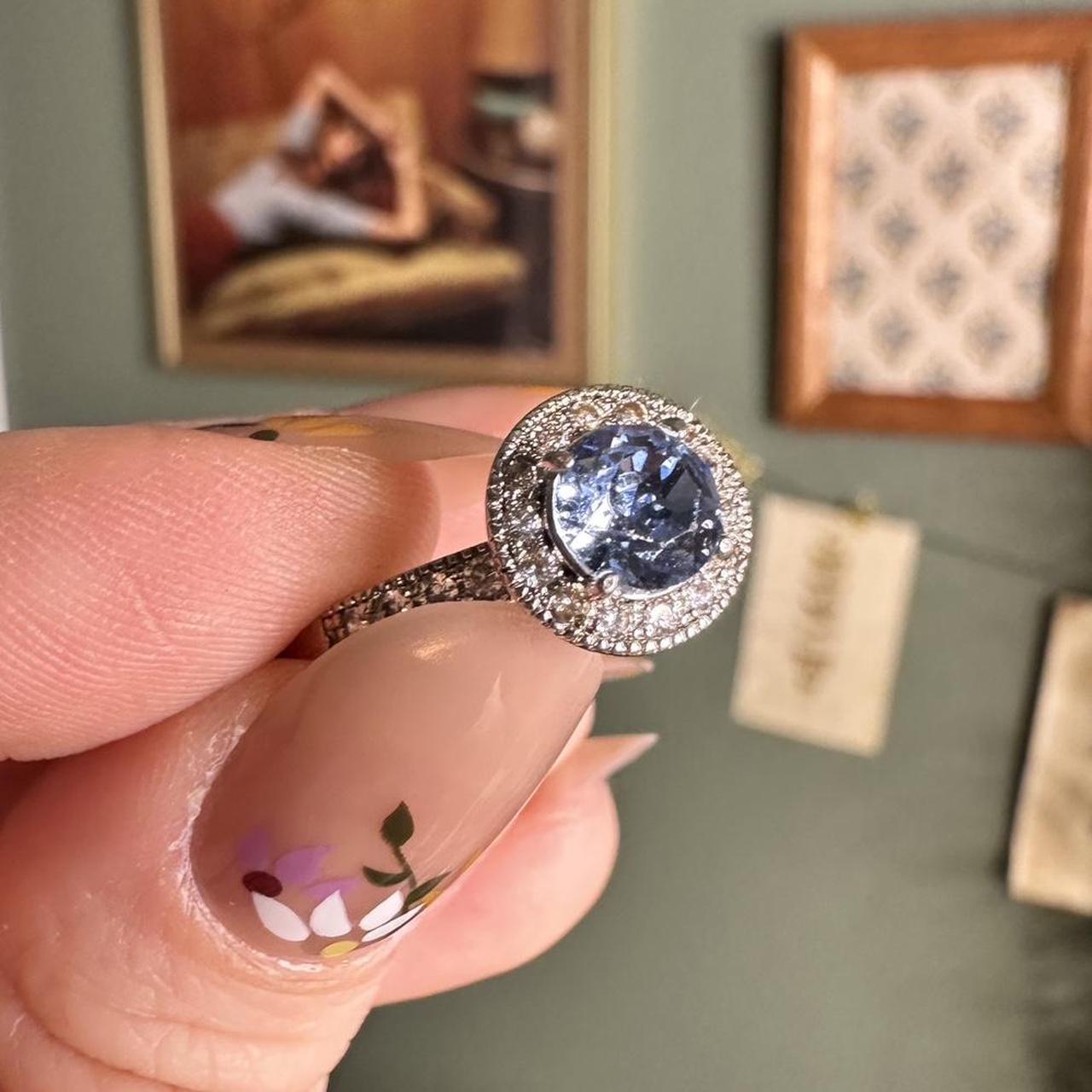 Silver toned ring with blue stone in center of tiny... - Depop