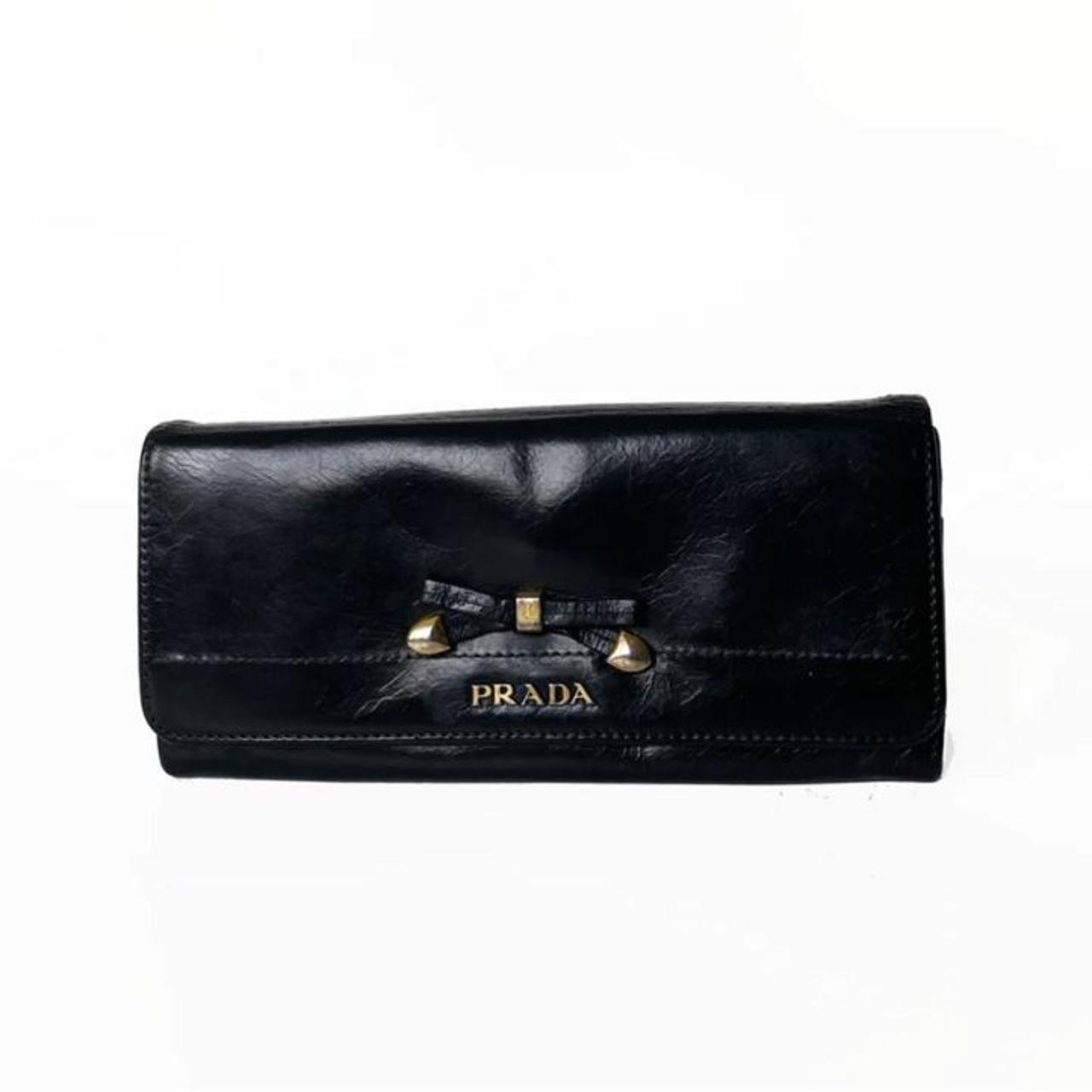 Black leather Prada wallet with gold bow details.... - Depop