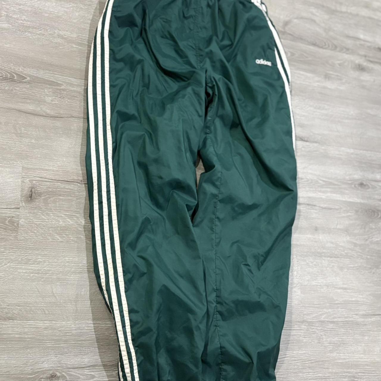 Green Adidas track pants with white stripes... | Depop